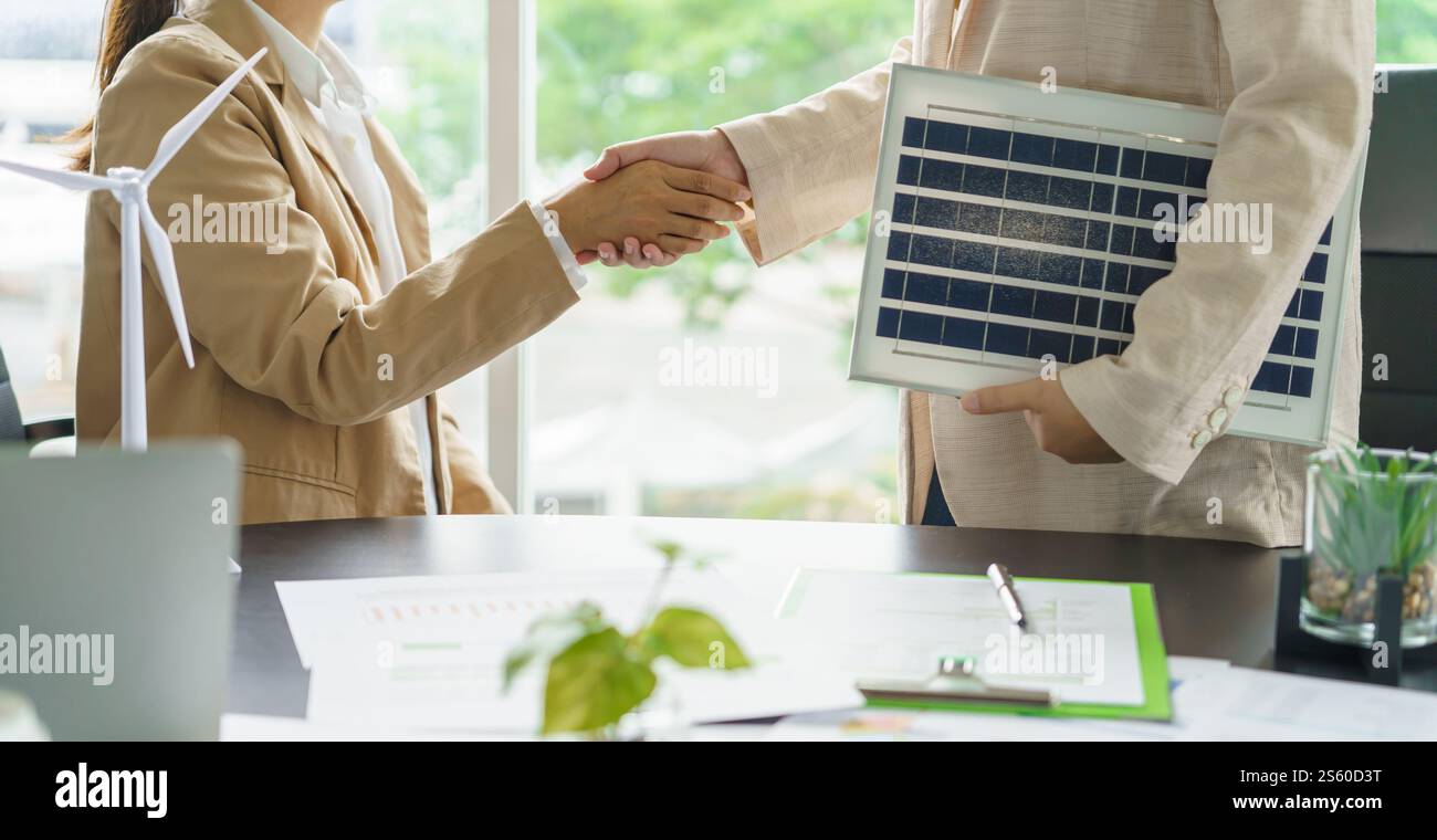 Handshake and business with solar panels green energy Business people working in green eco ...