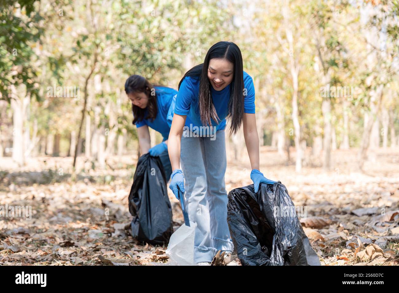 Volunteers participating in garbage collection in a forest, promoting ...