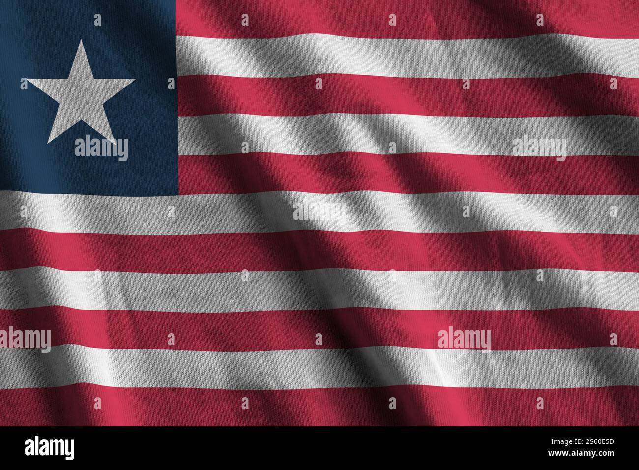 Liberia flag with big folds waving close up under the studio light ...
