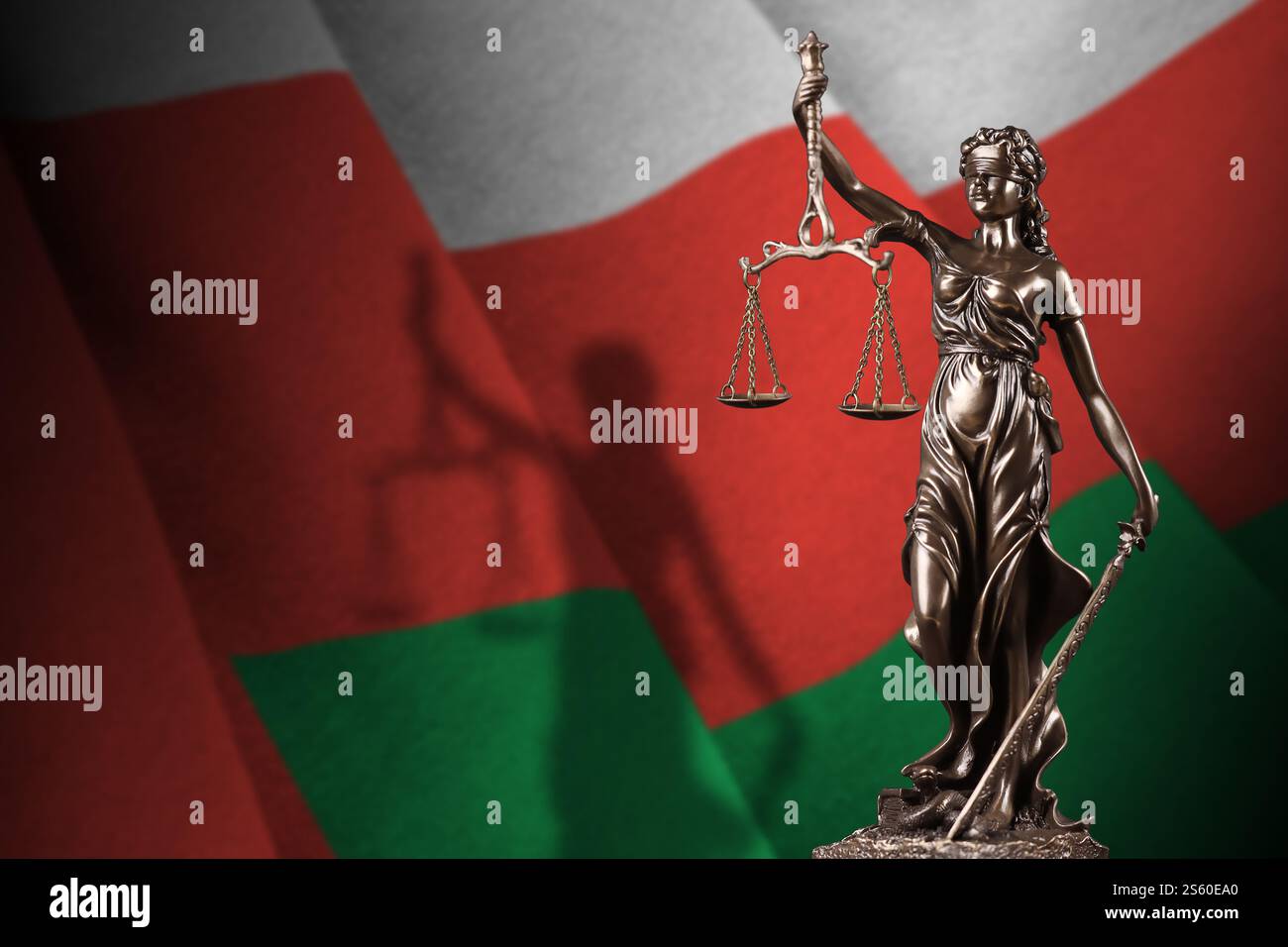 Oman flag with statue of lady justice and judicial scales in dark room. Concept of judgement and ...