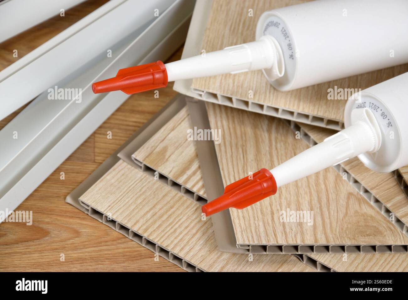 Set of items for PVC ceiling indoor works. Assembly adhesive bottles and PVC panels with plastic ...