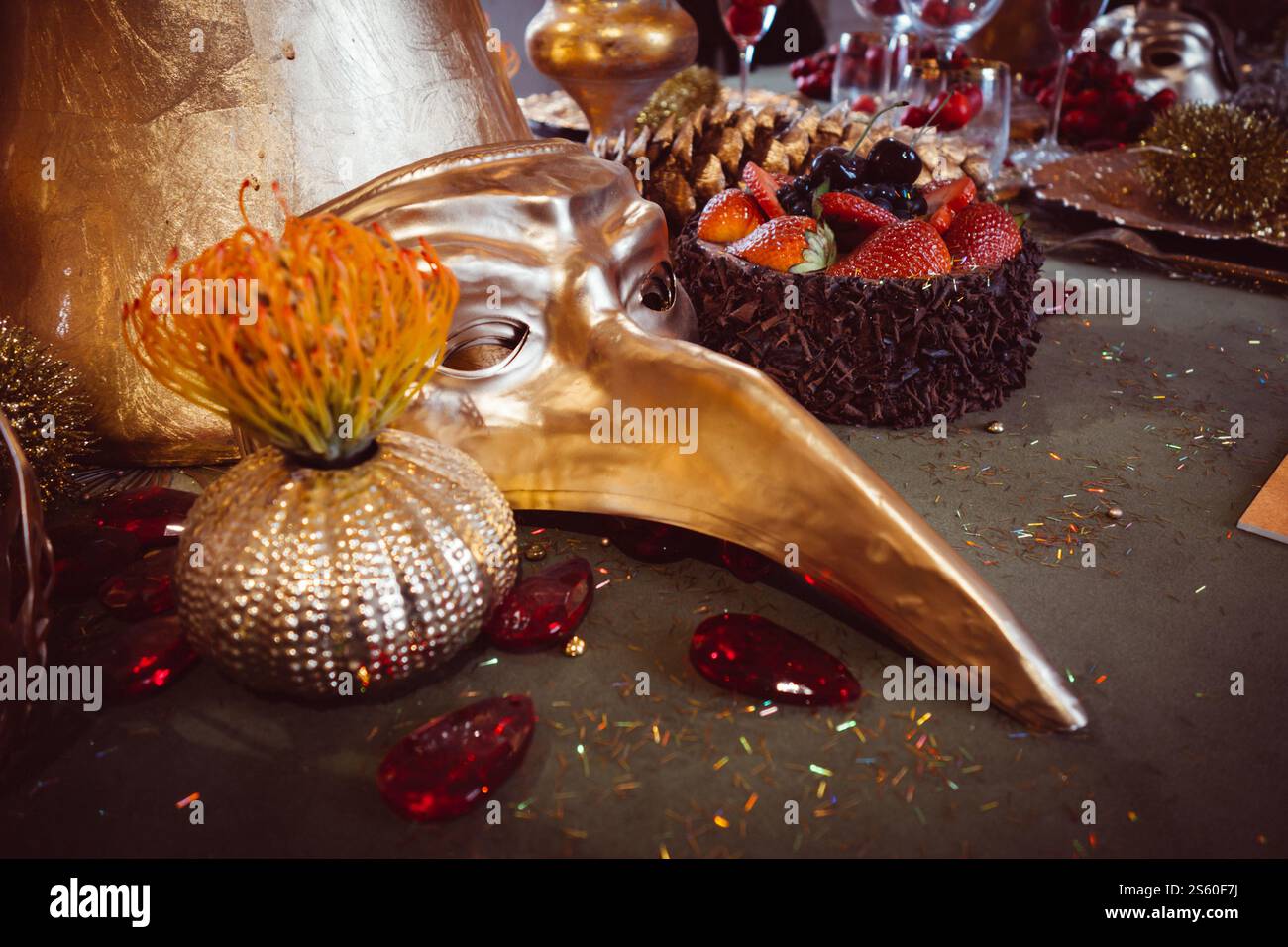 Gold Venetian mask on a table during carnival celebration. Gold ...
