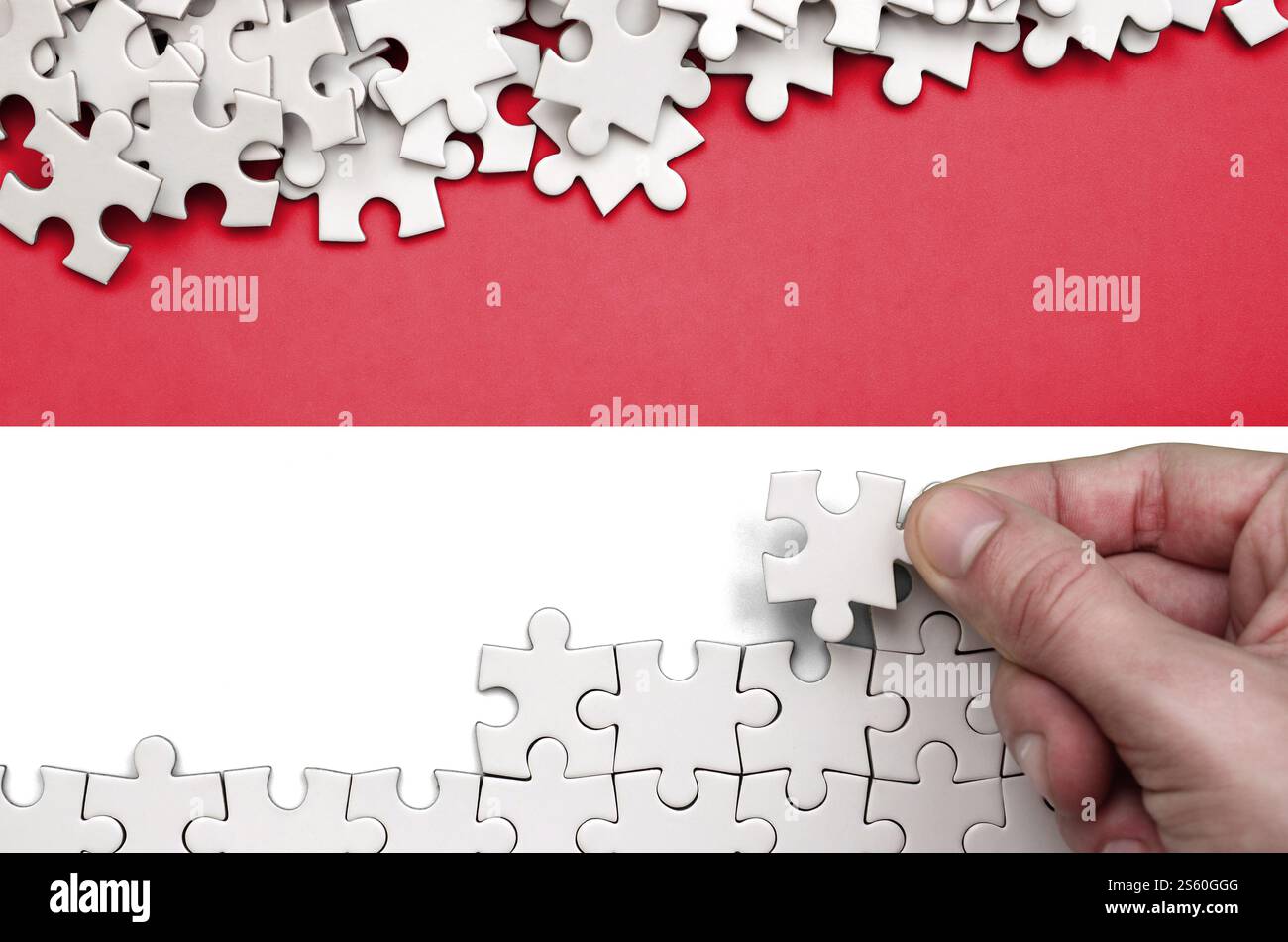 Monaco flag is depicted on a table on which the human hand folds a ...