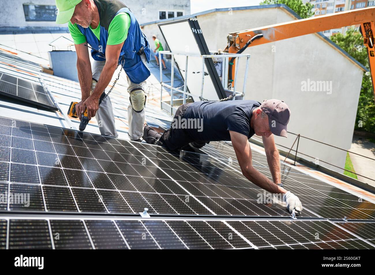 Workers building photovoltaic solar panel system on metal rooftop of ...