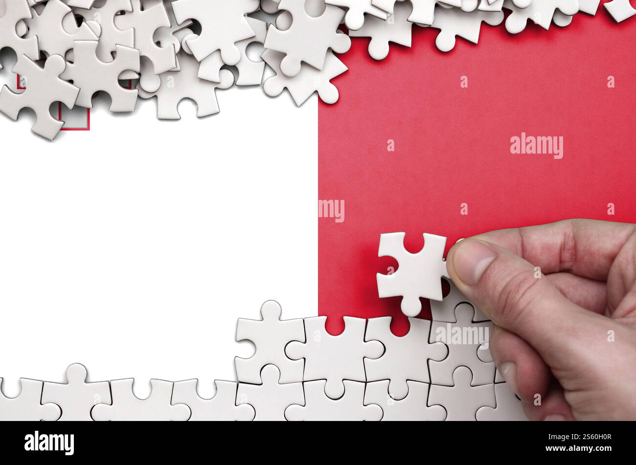 Malta flag is depicted on a table on which the human hand folds a ...