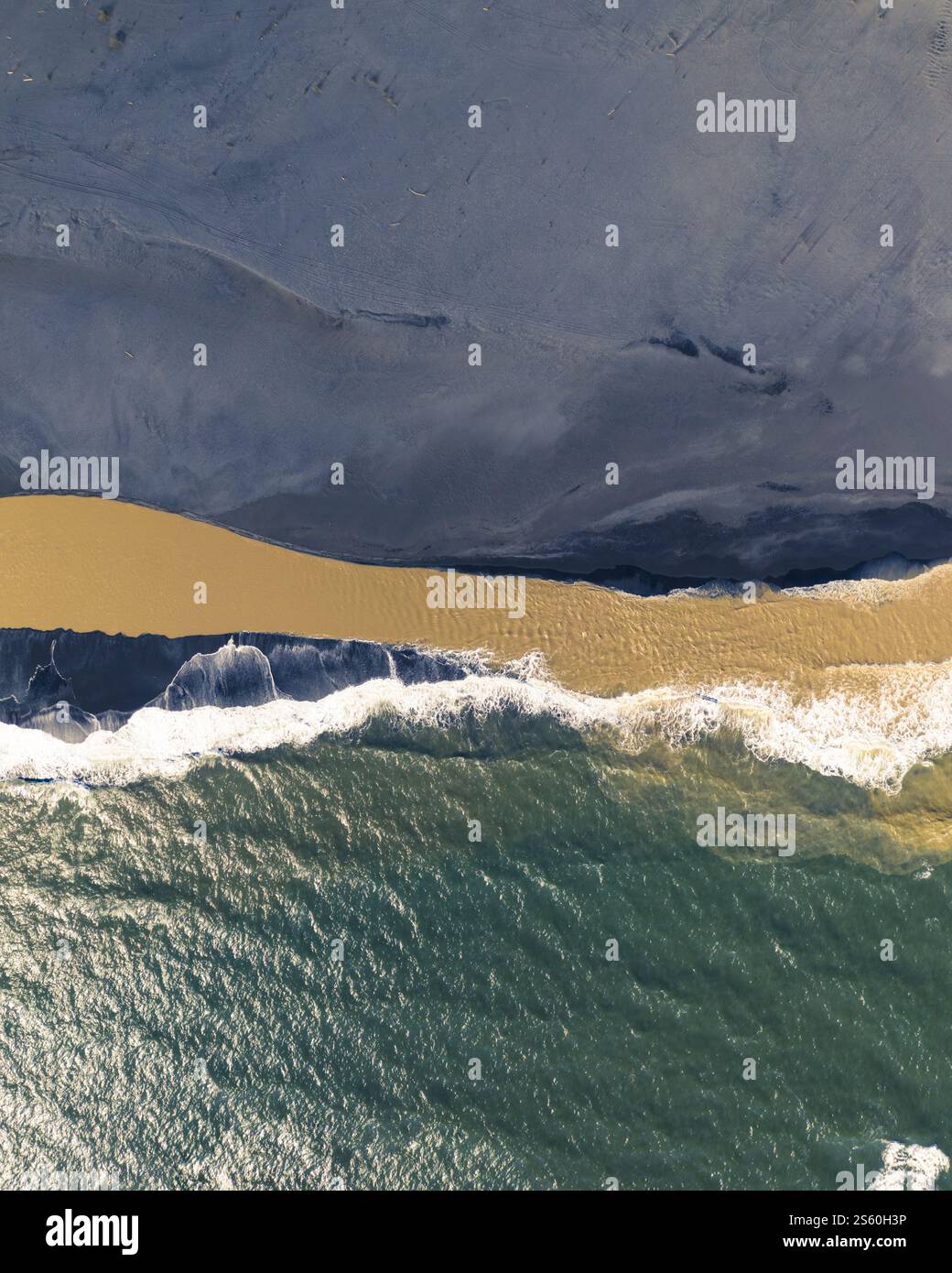 Aerial view of a river meeting the ocean with contrasting colors in ...