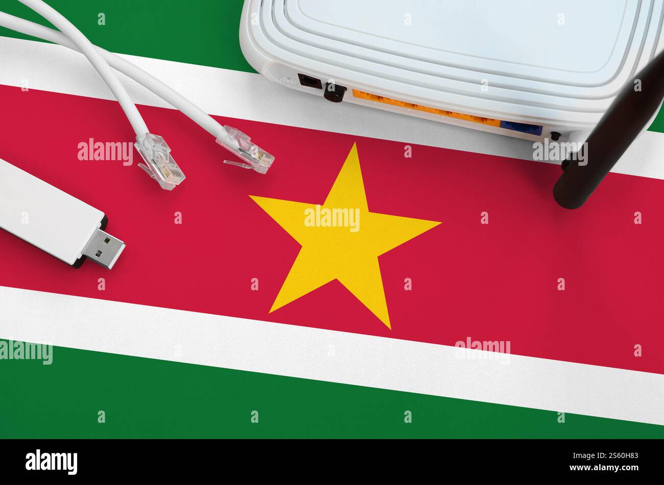 Suriname flag depicted on table with internet rj45 cable, wireless usb ...