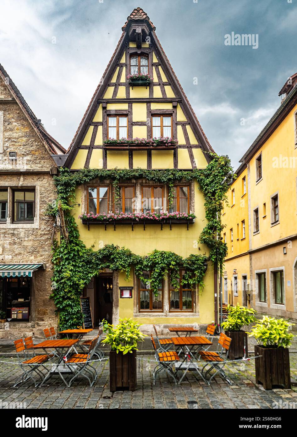 Charming medieval street featuring colorful half-timbered houses, ivy ...