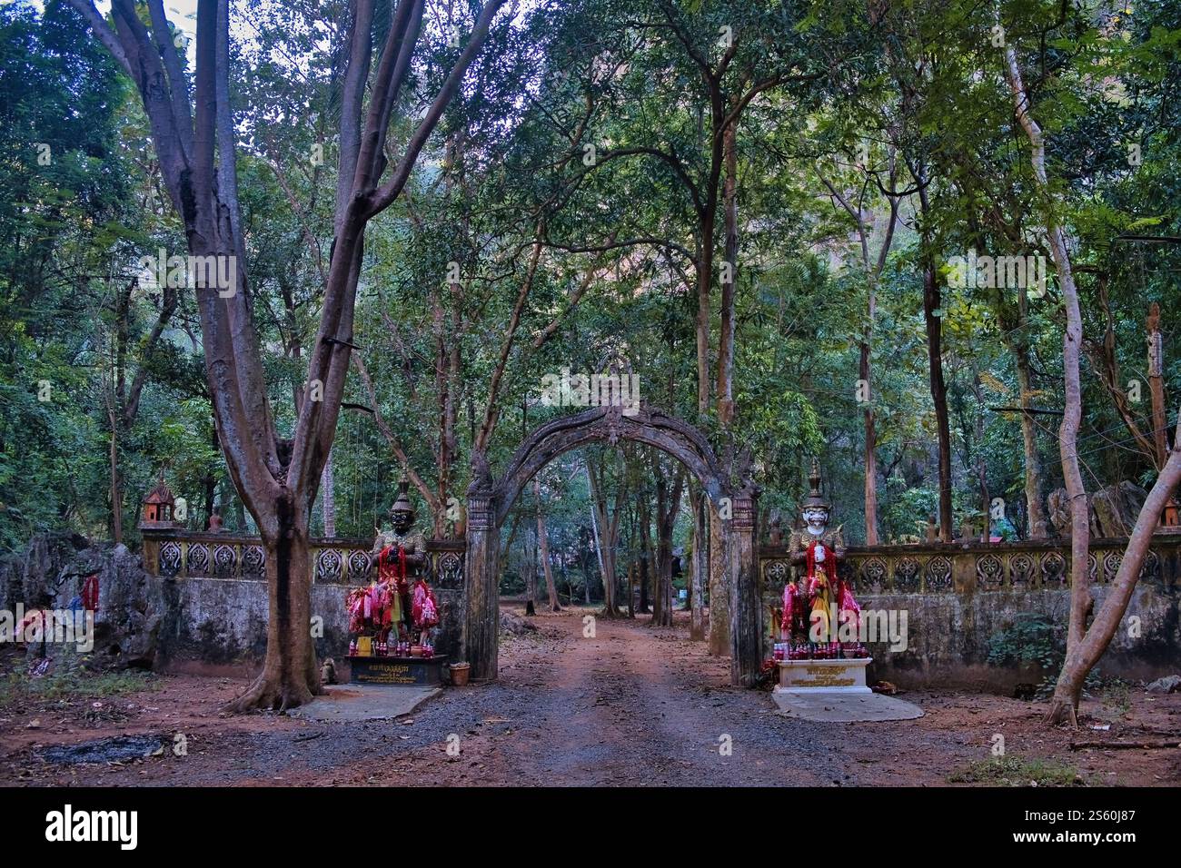 Old, mysterious stone entrance gate to the forest monastery of Wat Ban ...
