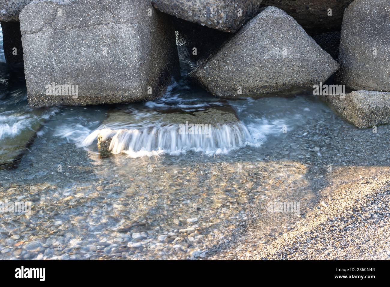 Detail of a beach. Breakwaters on the coastline. One of them deeper in ...