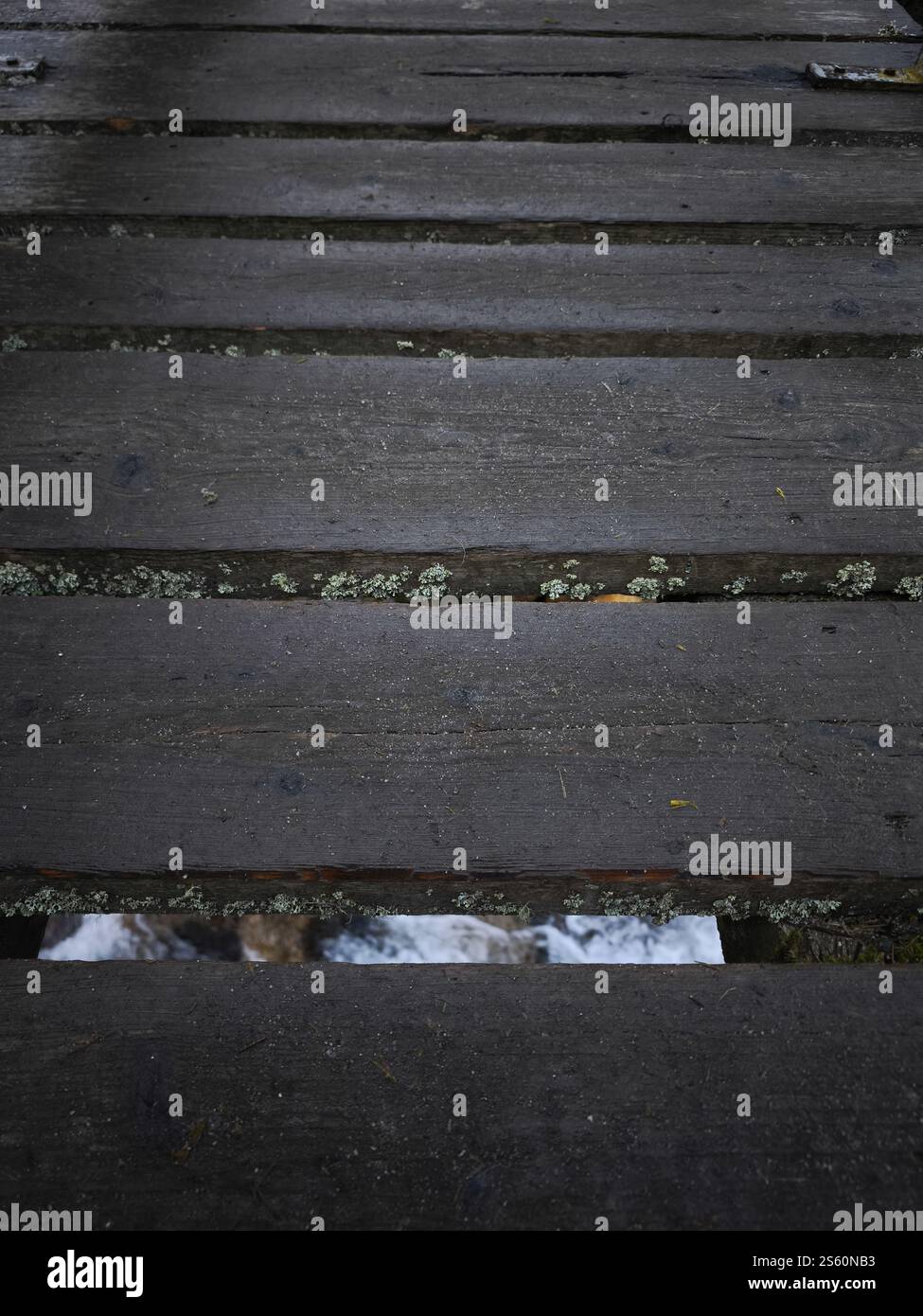 Wooden bridge with gaps between planks revealing river underneath in ...