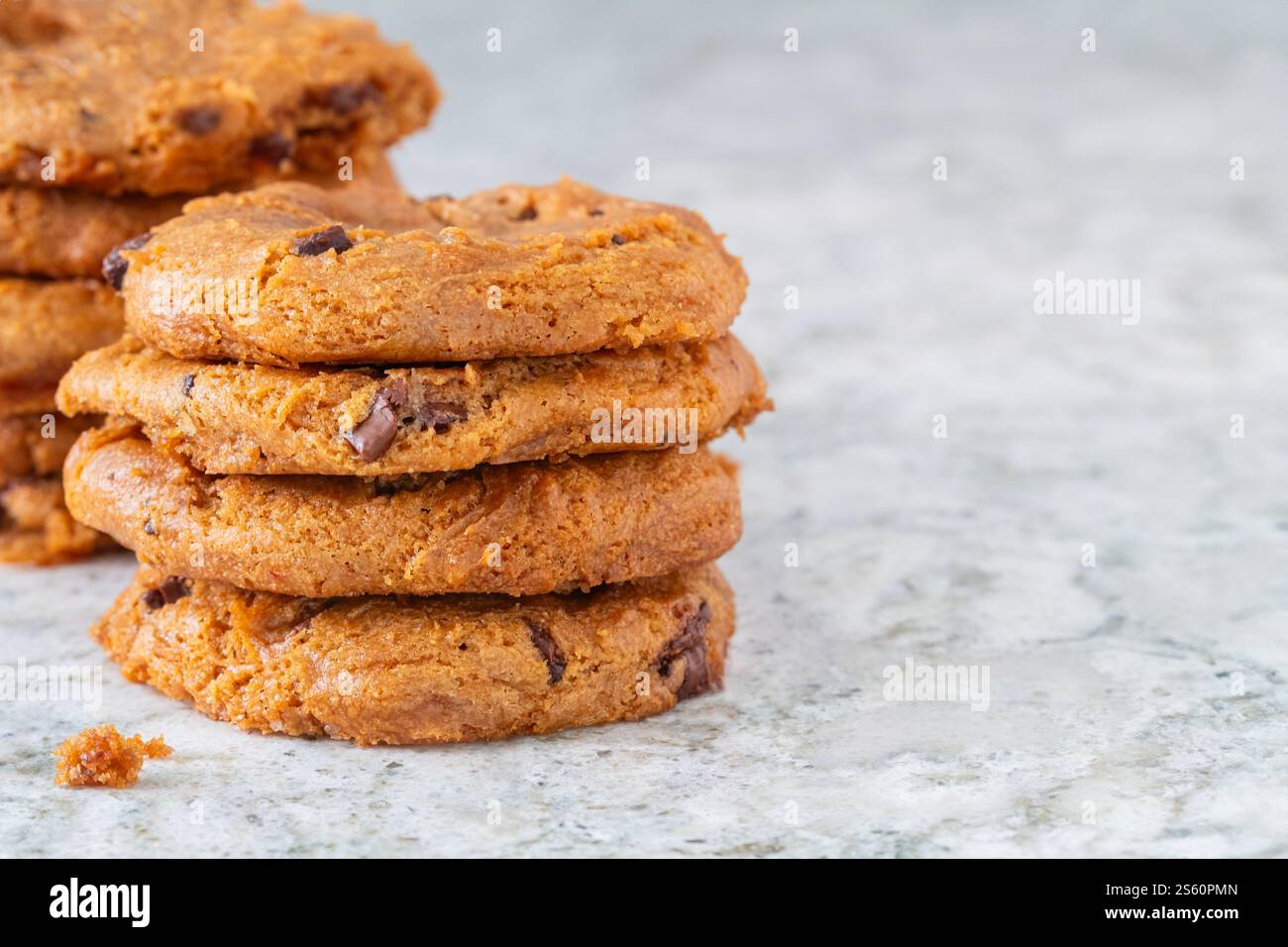 Stacks of hot and gooey chocolate chip cookies on a white granite ...