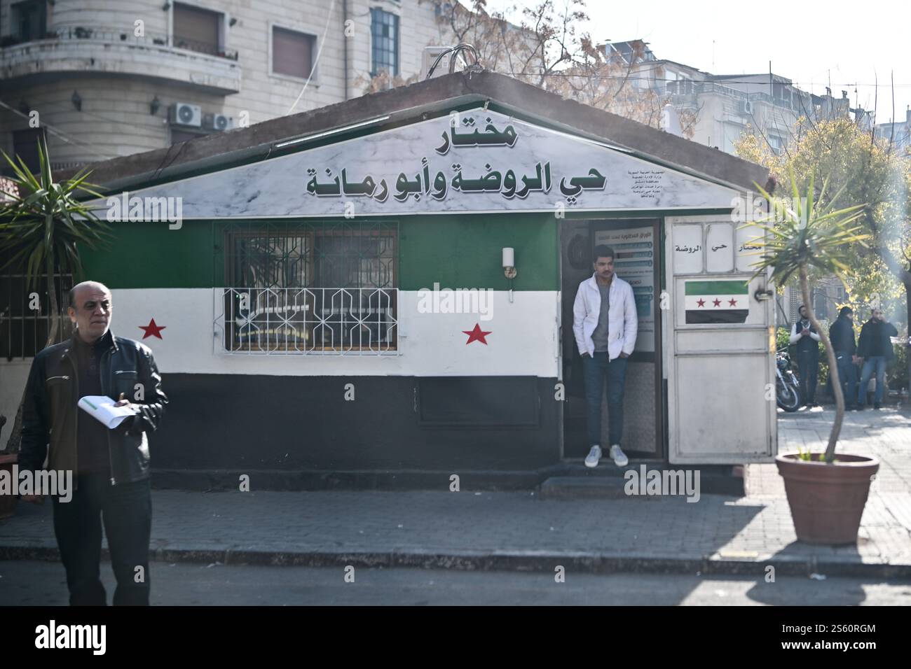 15 January 2025, Syria, Damaskus: Men stand at a house with the Syrian ...