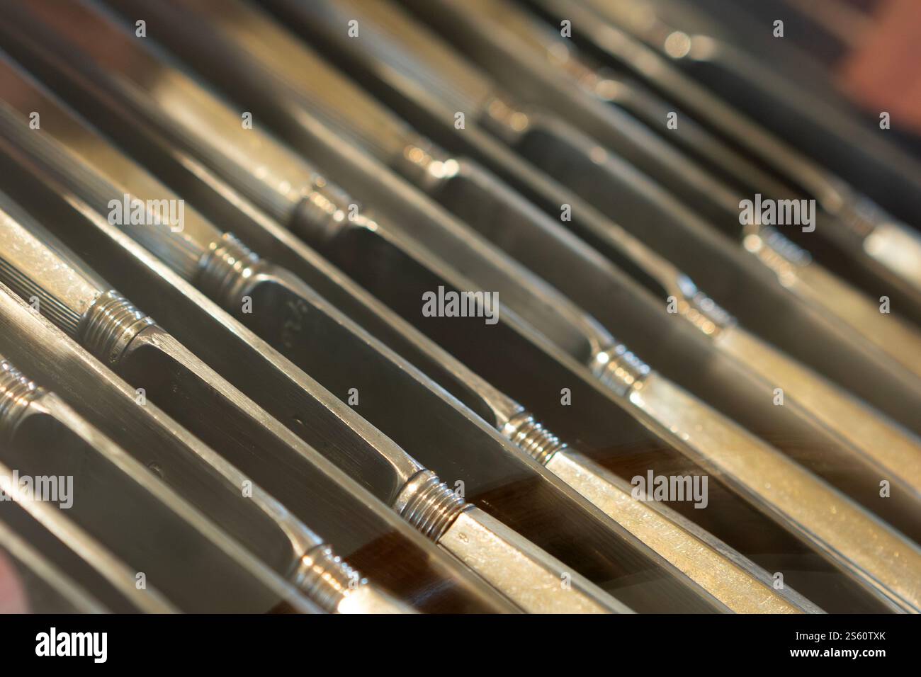 A detailed closeup of polished metal grooves and threads arranged in a ...