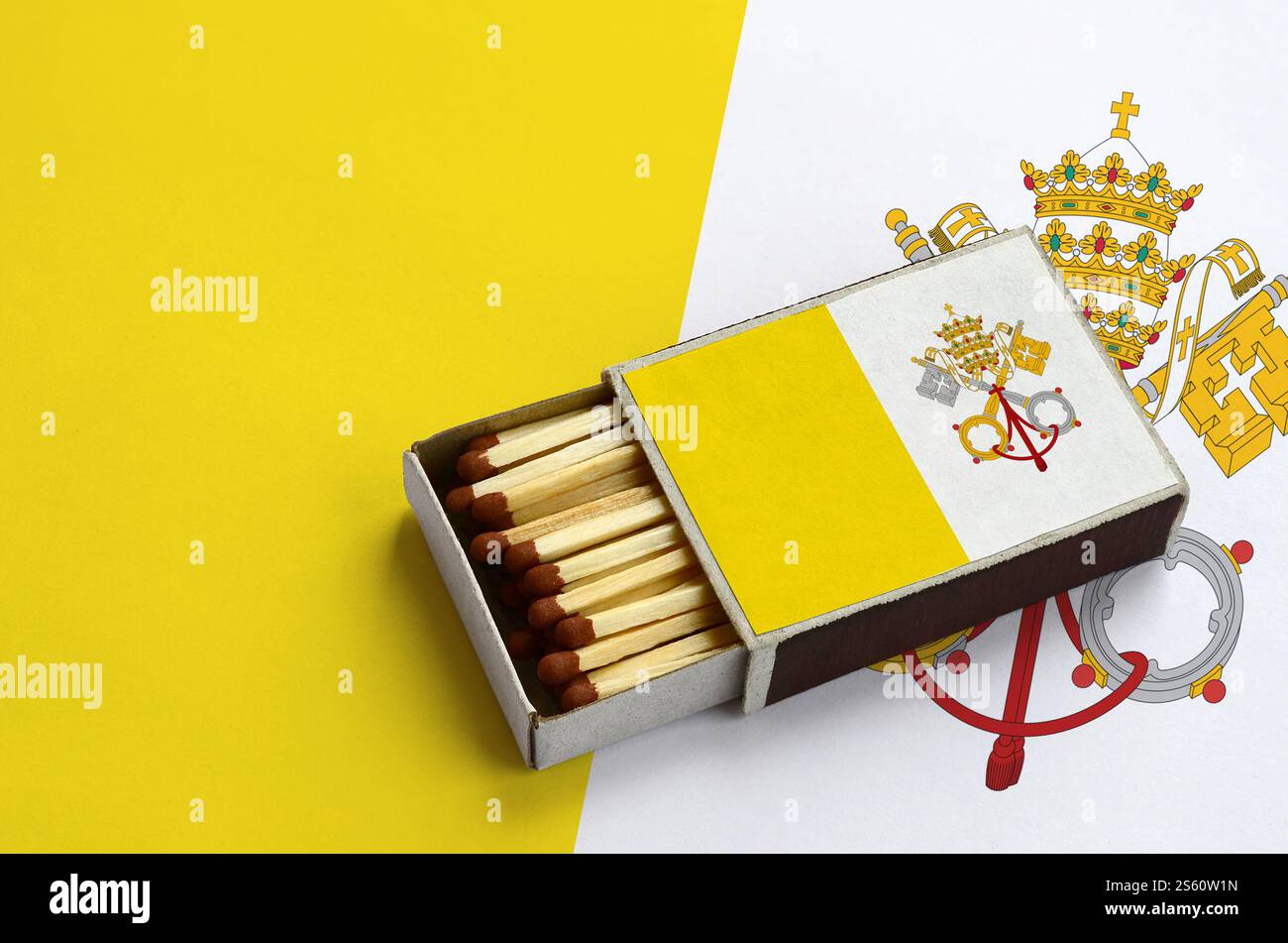 Vatican City State flag is shown in an open matchbox, which is filled ...