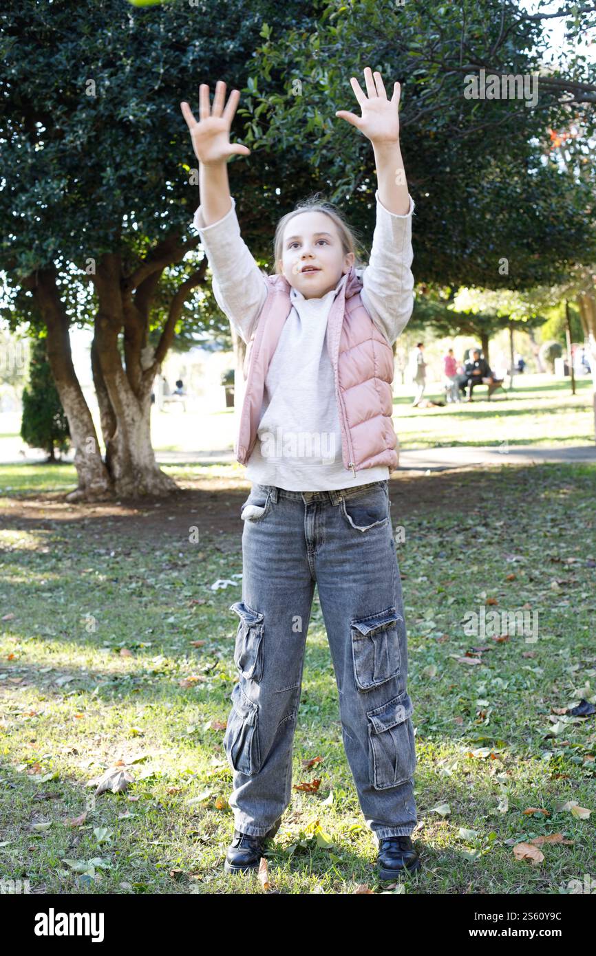 Cheerful child girl catching flying disc in park. Happiness and ...