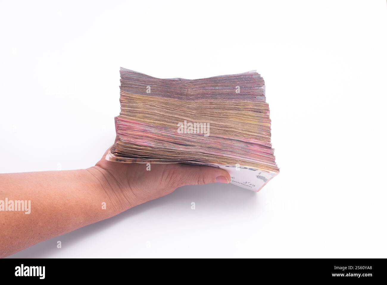 a large stack of paper money in a hand. on a white background Stock ...