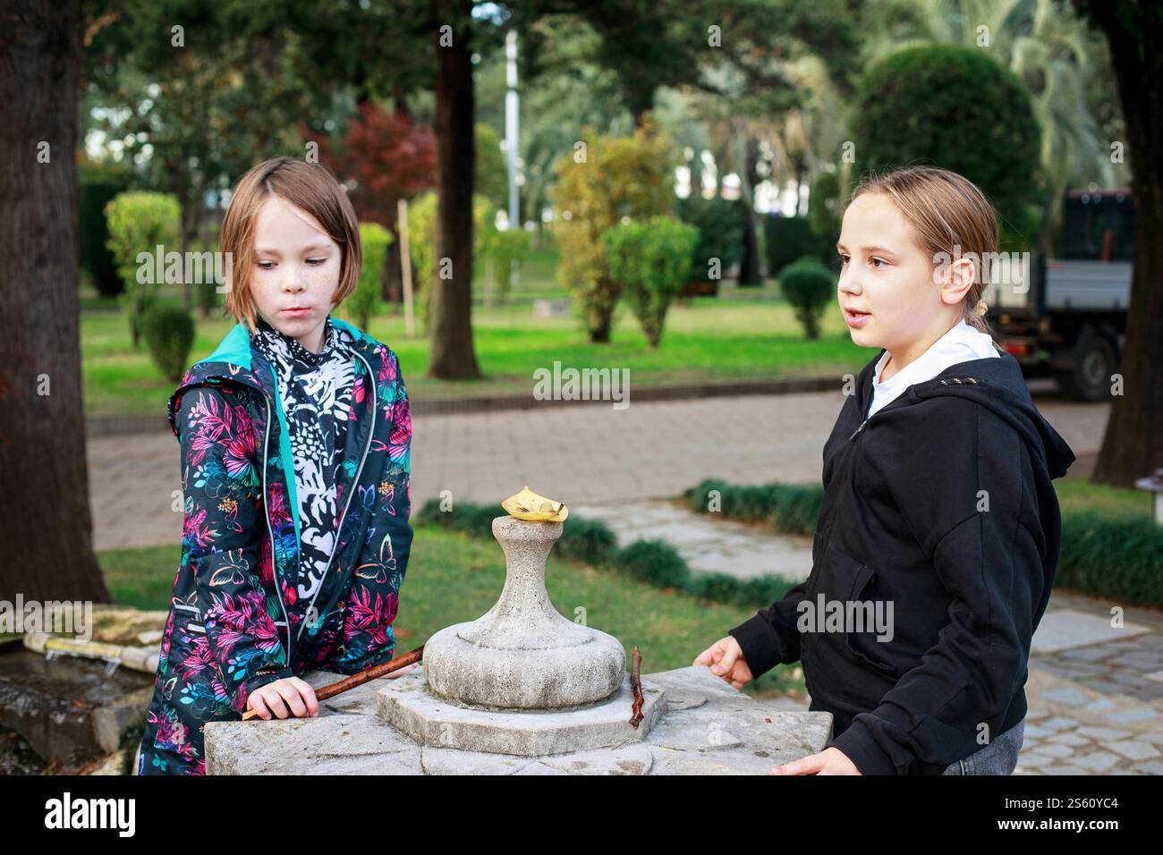 Attractive two child girls having fun together in park, outdoors ...