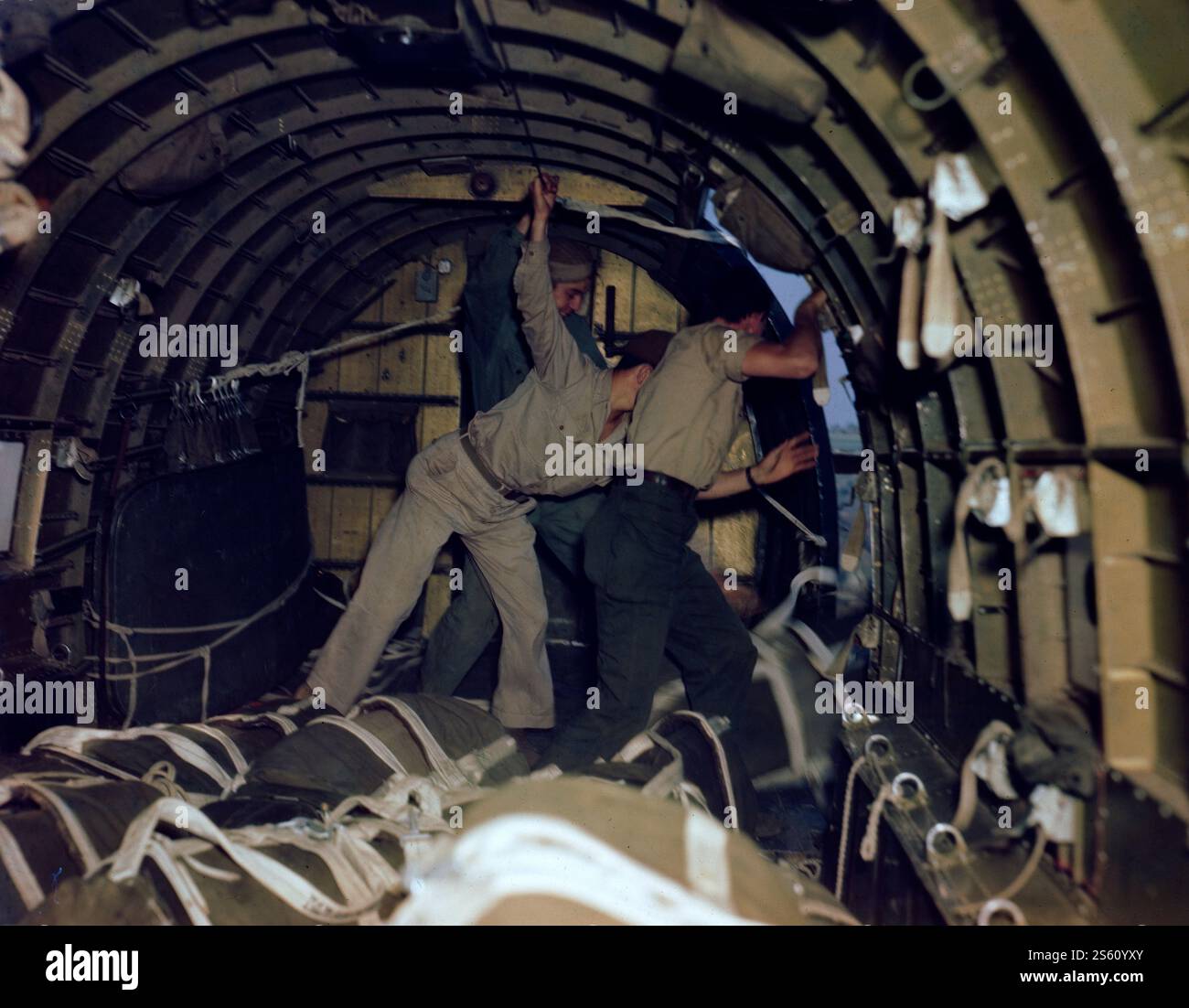 Dropping mission over Burma. Men push supplies out of a transport plane ...