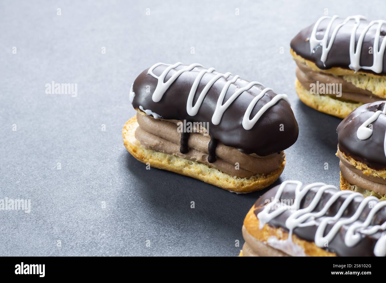Eclairs with black chocolate and white chocolate with custard on rustic ...