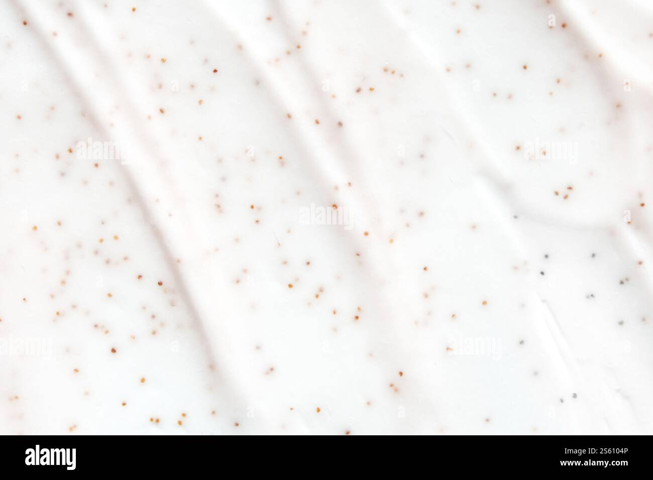 Smooth white cream texture with brown exfoliating microbeads for ...