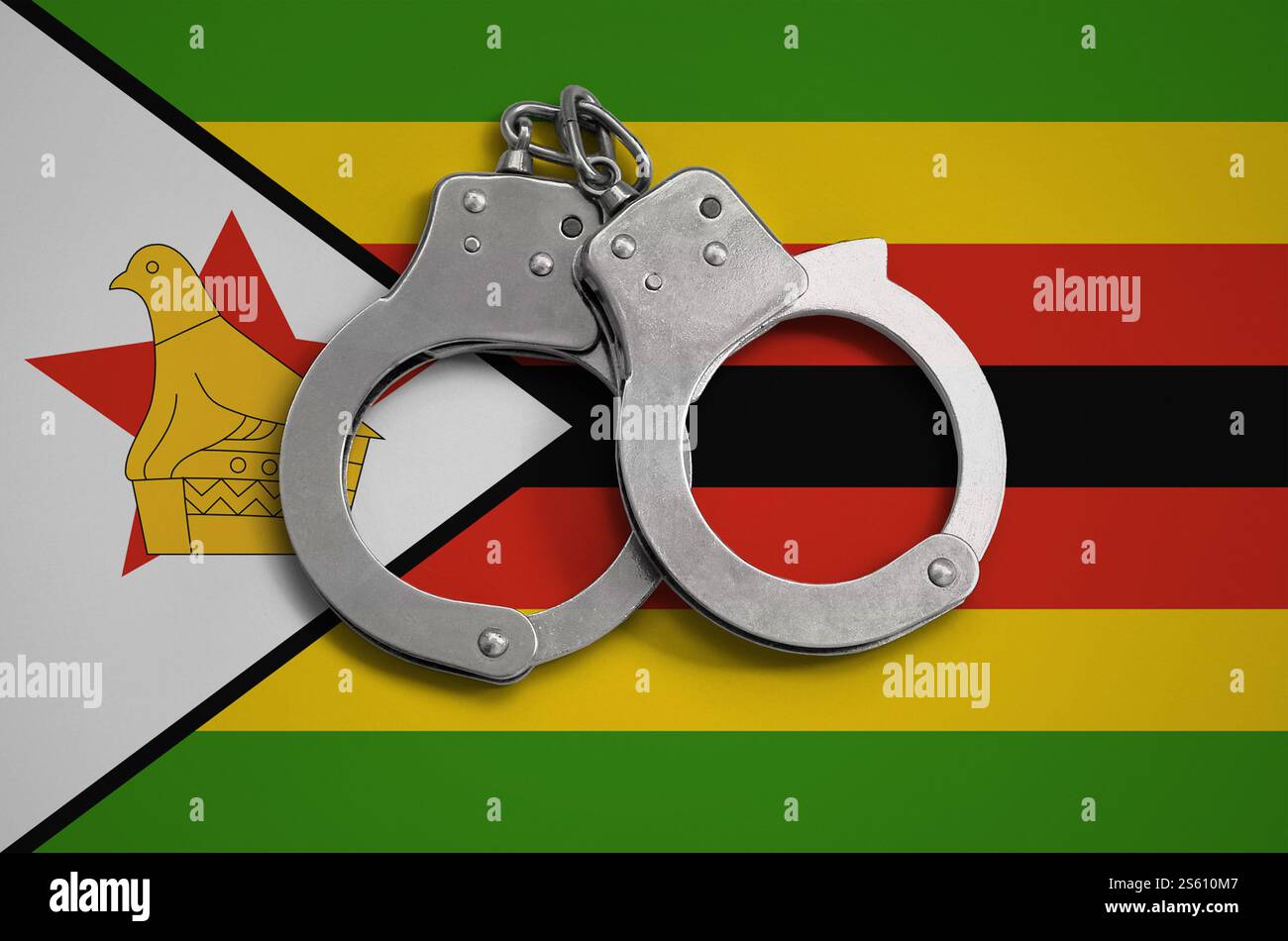 Zimbabwe flag and police handcuffs. The concept of observance of the ...