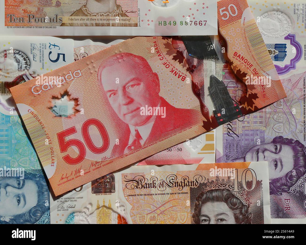 Colorful British pounds with Queen and Fifty Canadian Dollar Banknotes ...