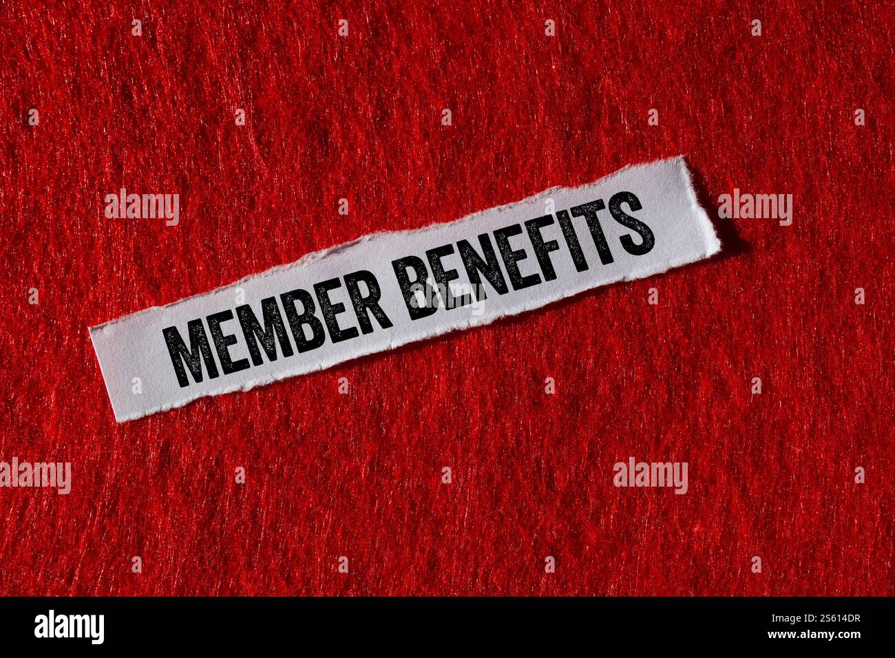Member benefits message written on ripped torn paper piece on red background. Conceptual member ...