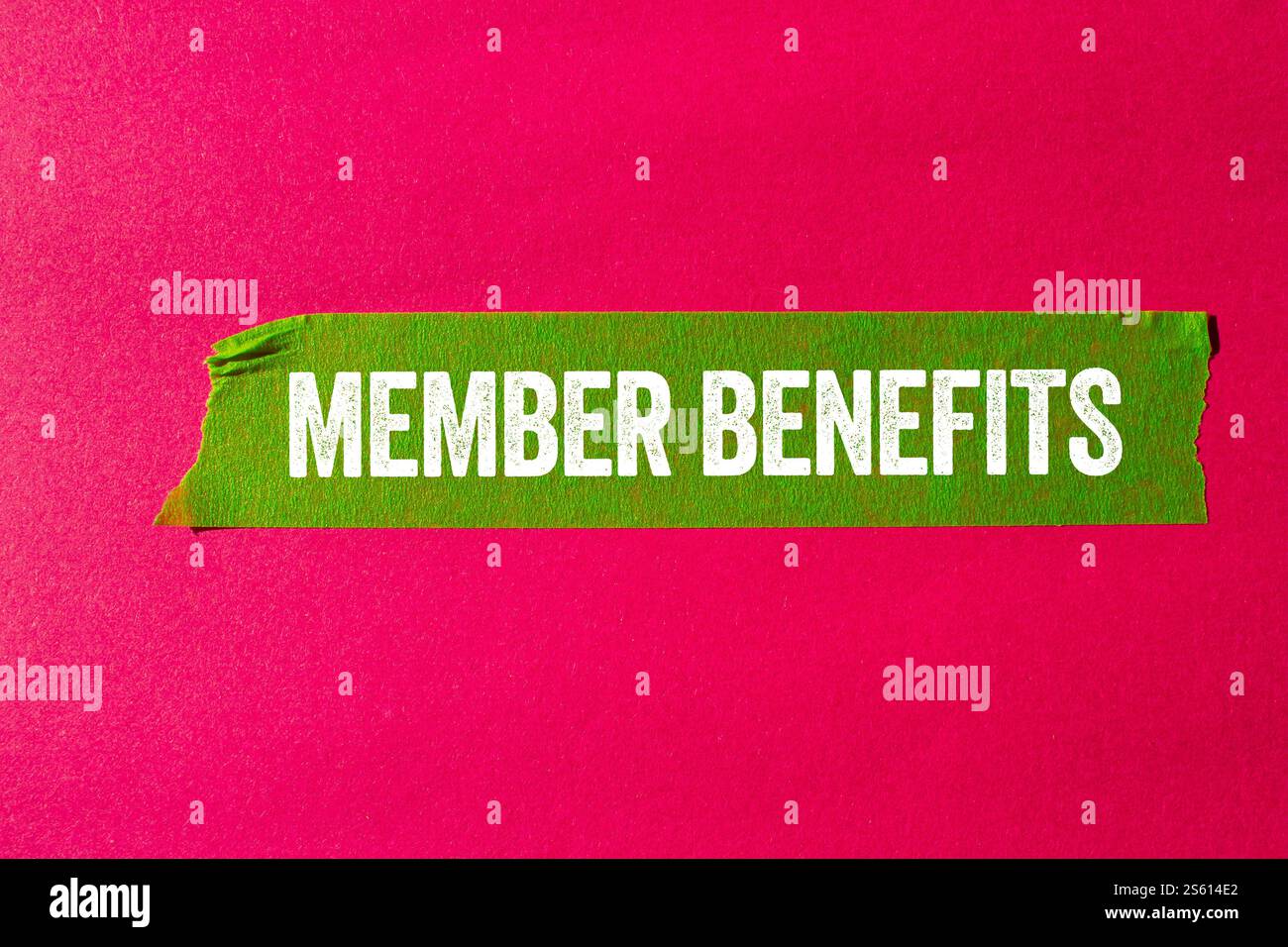 Member benefits message written on ripped torn green paper tape on pink background. Conceptual ...