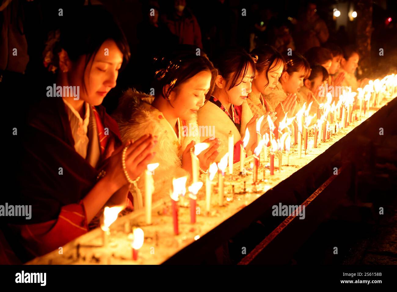 Women clad in kimono (Japanese traditional clothing) pray for their ...
