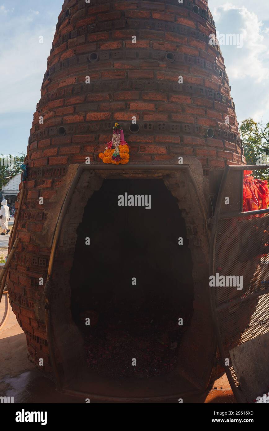 A large, conical brick kiln with a dark cavity at its base, adorned ...