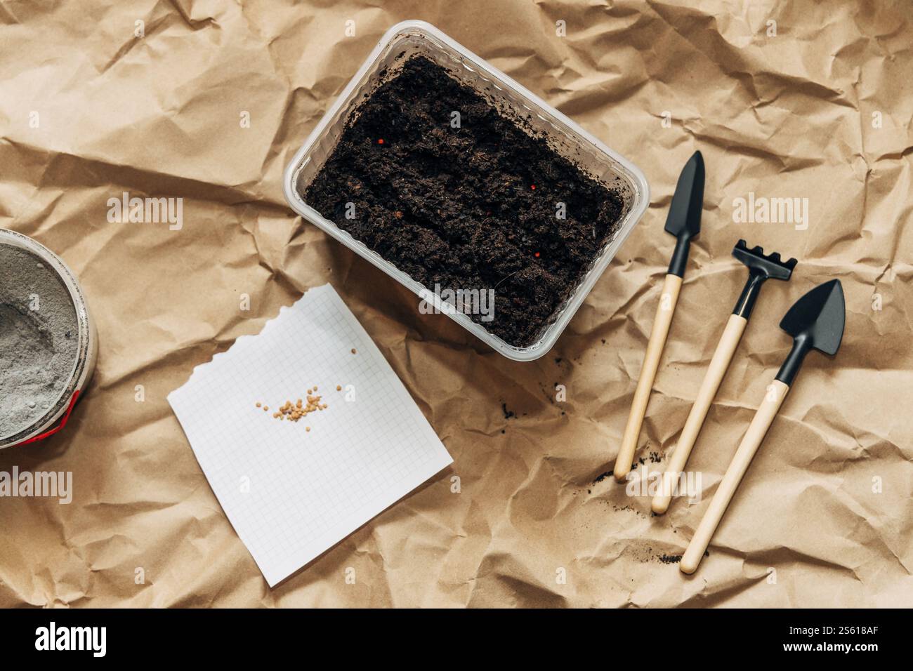 Kraft paper background, fertile soil and garden tools on top, top view ...