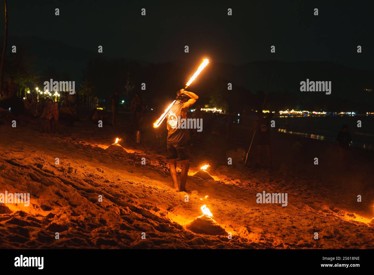 Fire Performer Spinning Flaming Staff on a Beach at Night in Thailand ...