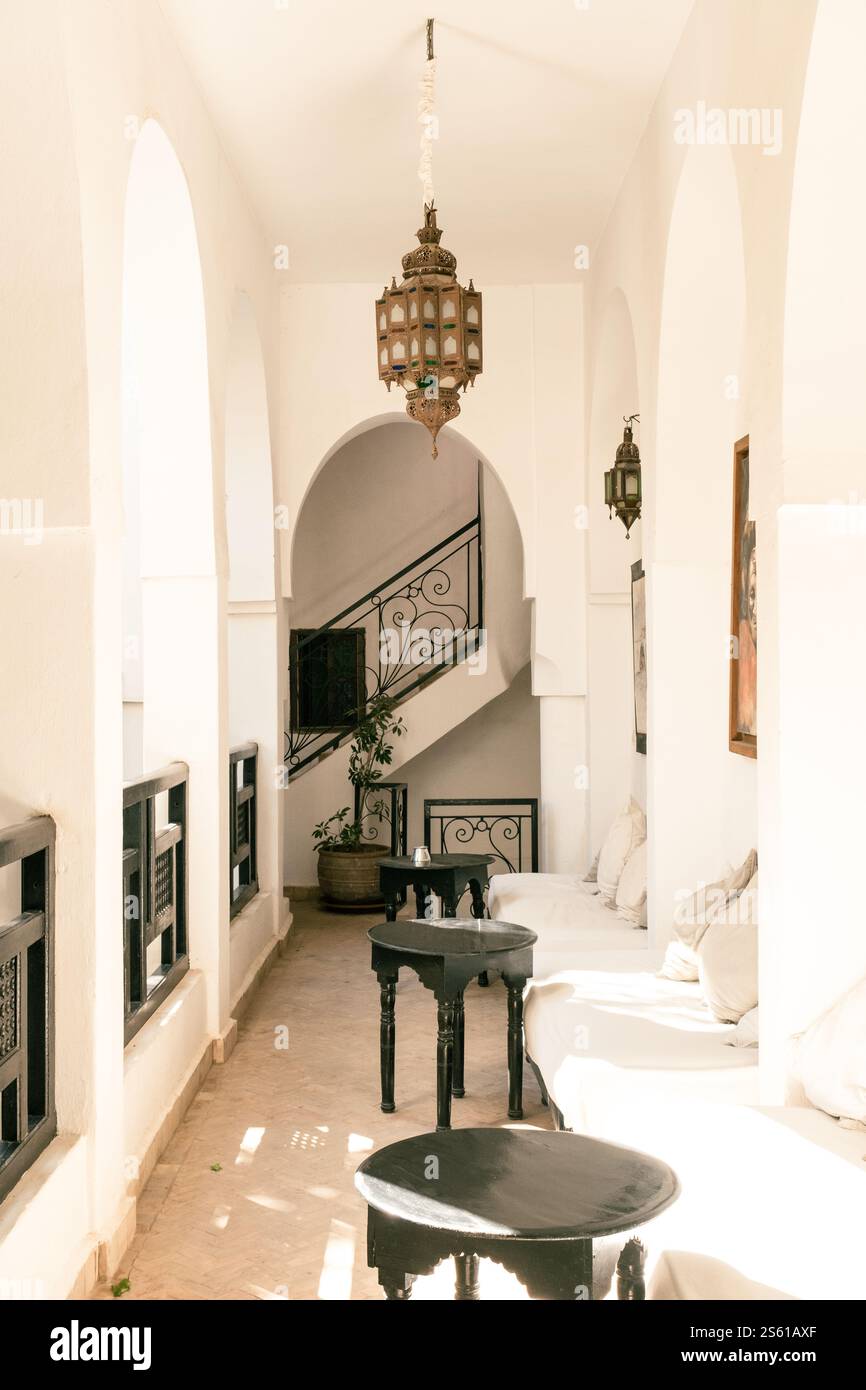 Hallway with a moorish arch, white walls and seats with black round ...