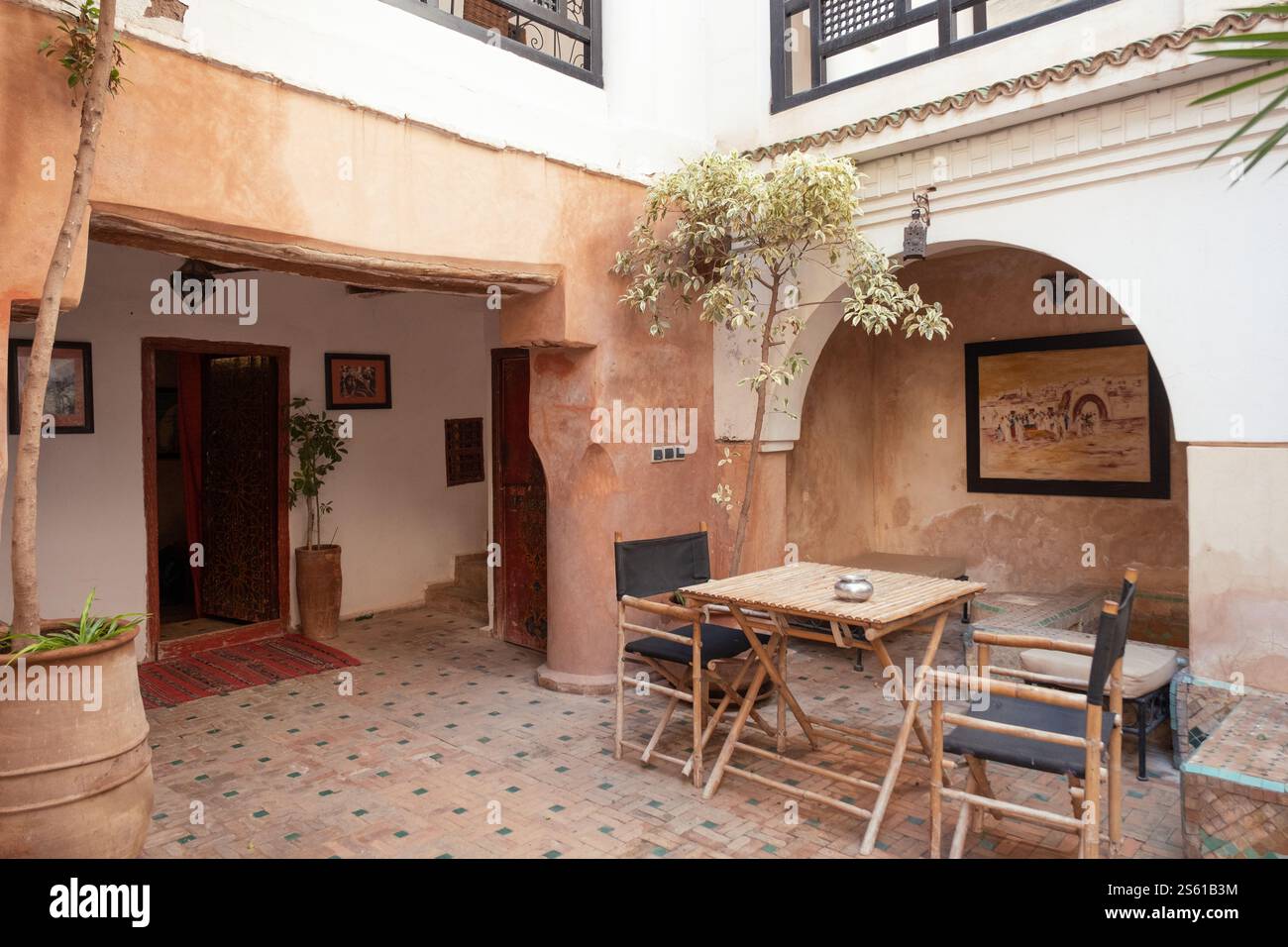 Table for two in the interior garden of a riyad with moorish arched and ...