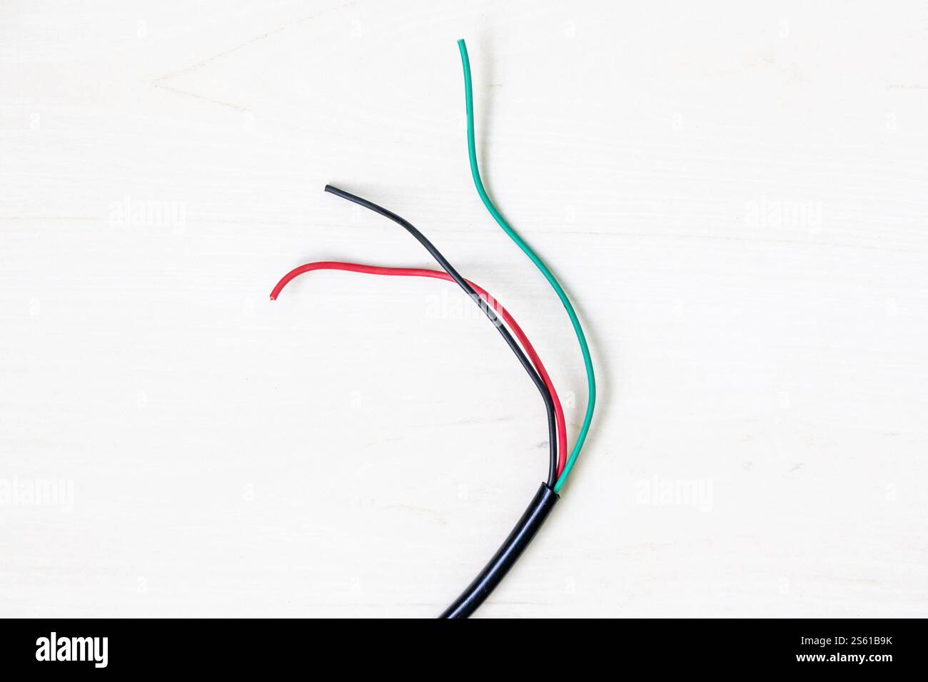 Used black, red, and green electrical cables are showcased on a white ...