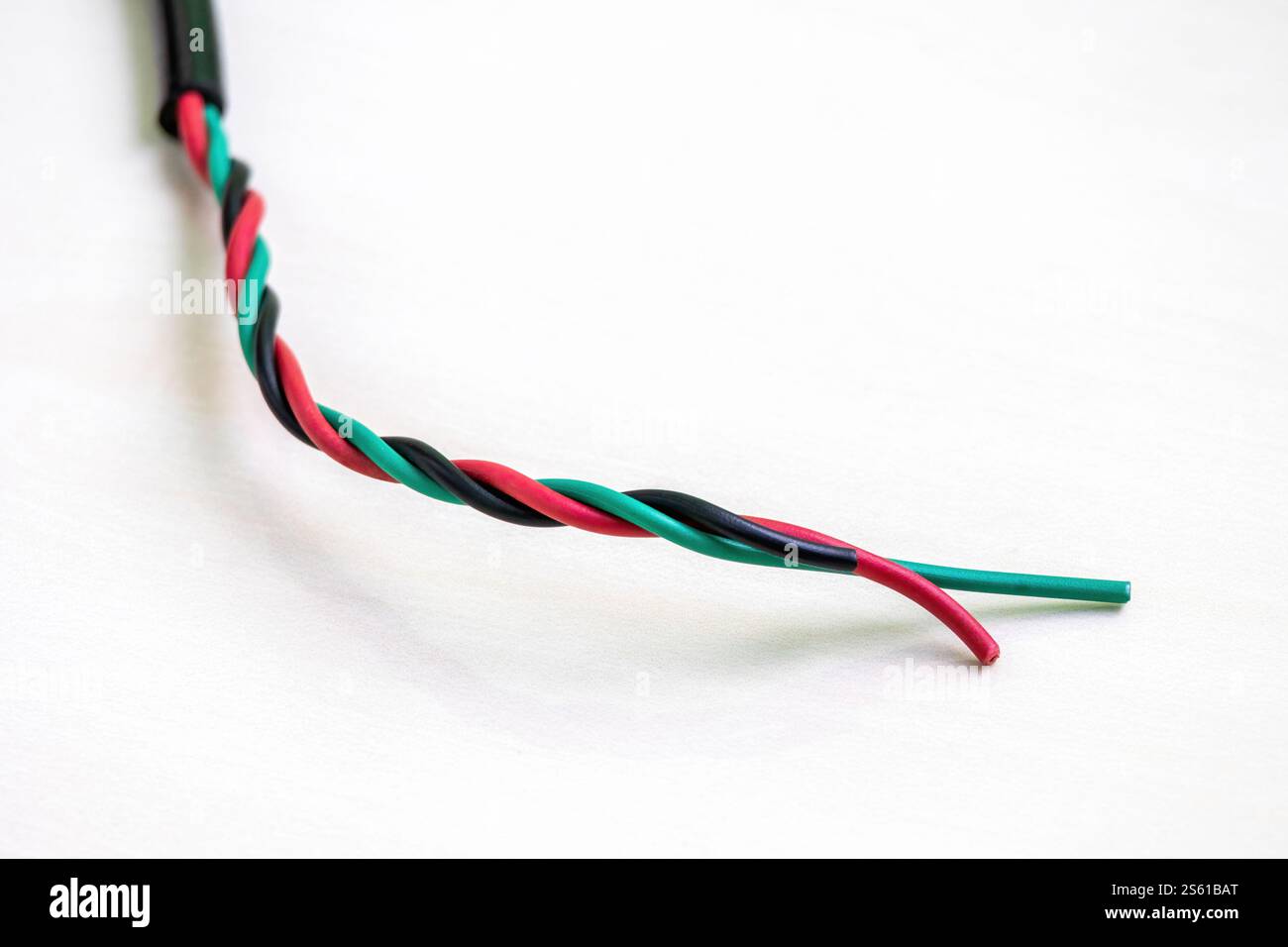 Red, green, and black twisted wires from a cut electrical cable on a ...