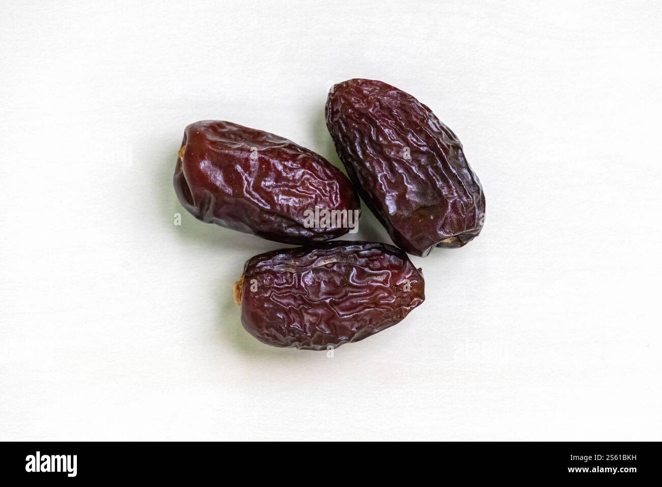 Three fresh, dried dates isolated on a white background. Top view Stock ...