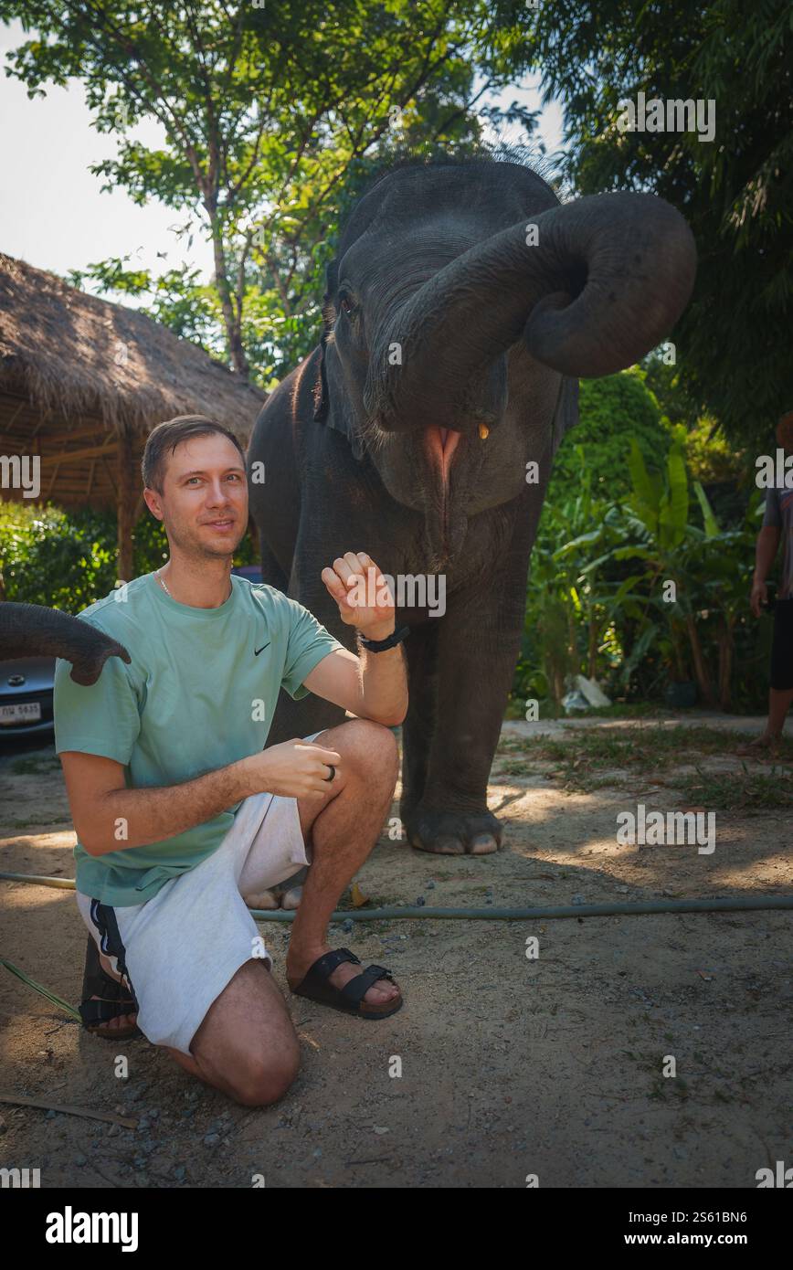 Man Interacting with Young Elephant in Tropical Setting, Thailand Stock ...