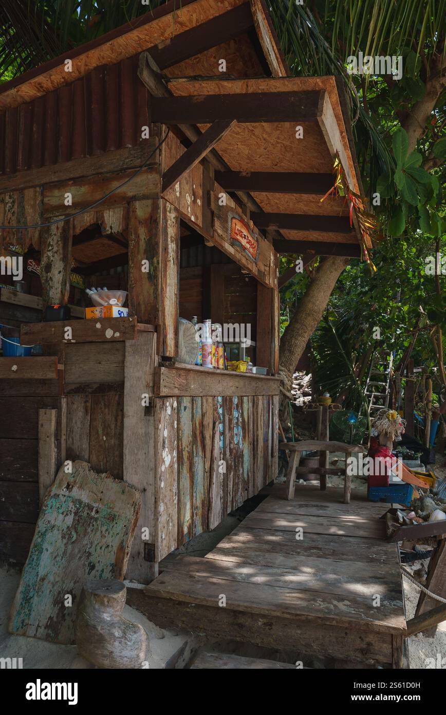 A weathered wooden shack with a corrugated metal roof surrounded by ...