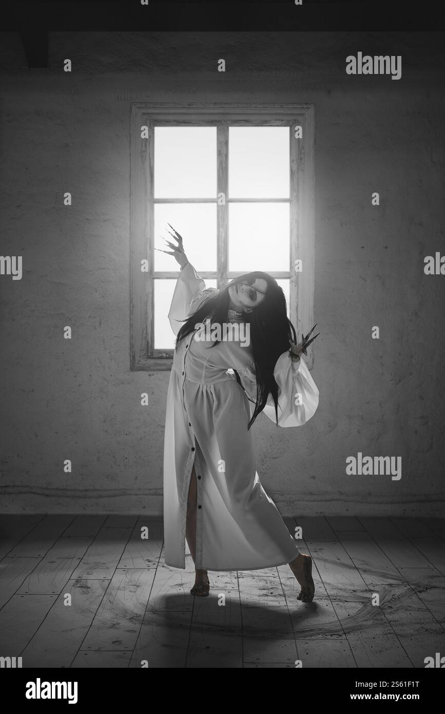 Woman with long dark hair, flowing white dress, black claws stands in ...