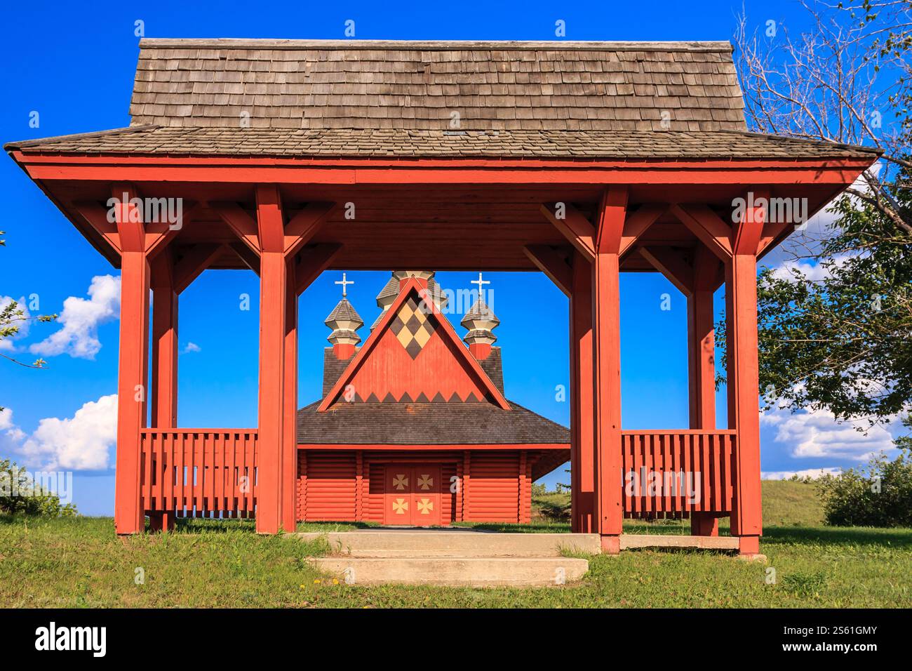 A red building with a gable roof and a cross on top. The building is ...