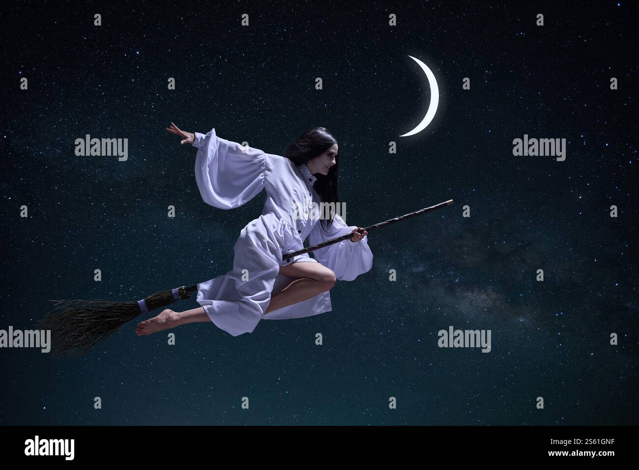 Witch with black hair, in flowing white dress sits on a broom and flies ...