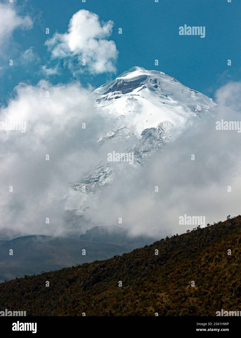 Cotopaxi volcano partially covered by clouds, with its snow-capped peak ...