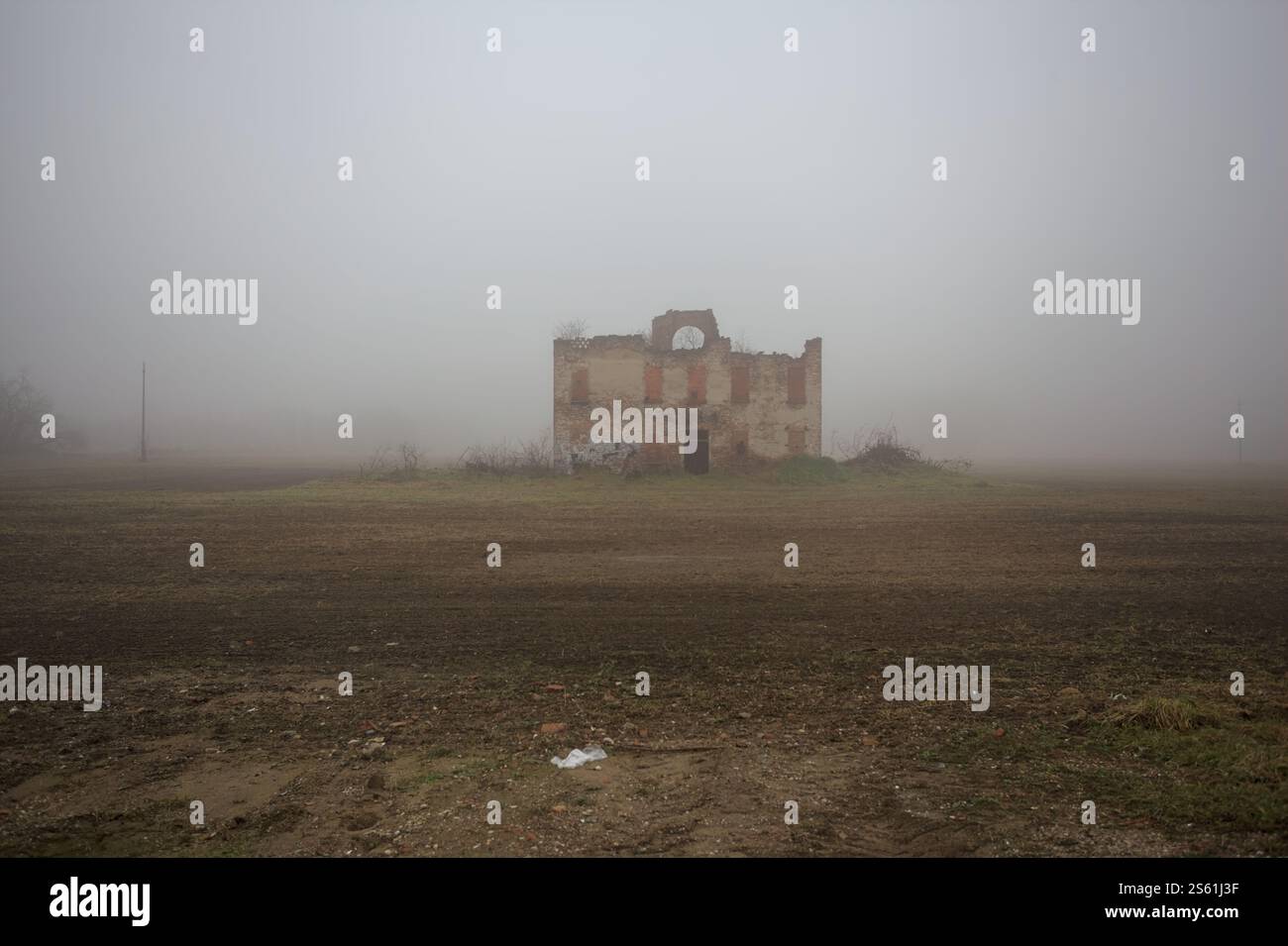 Run down country house in the middle of a field on a foggy day in the ...