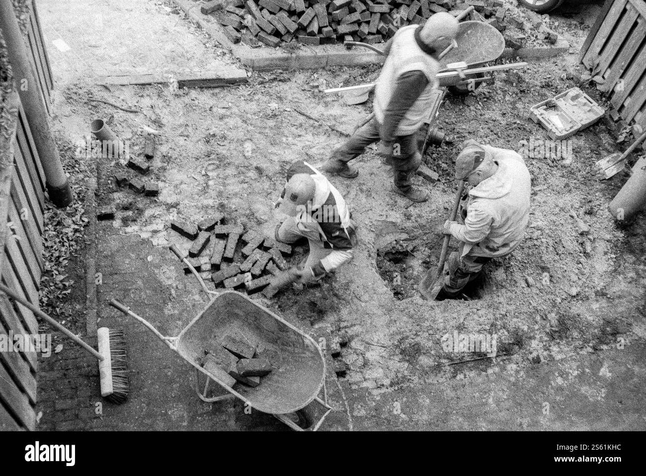 Three Street Workers installing New Pavement below an Apartment ...