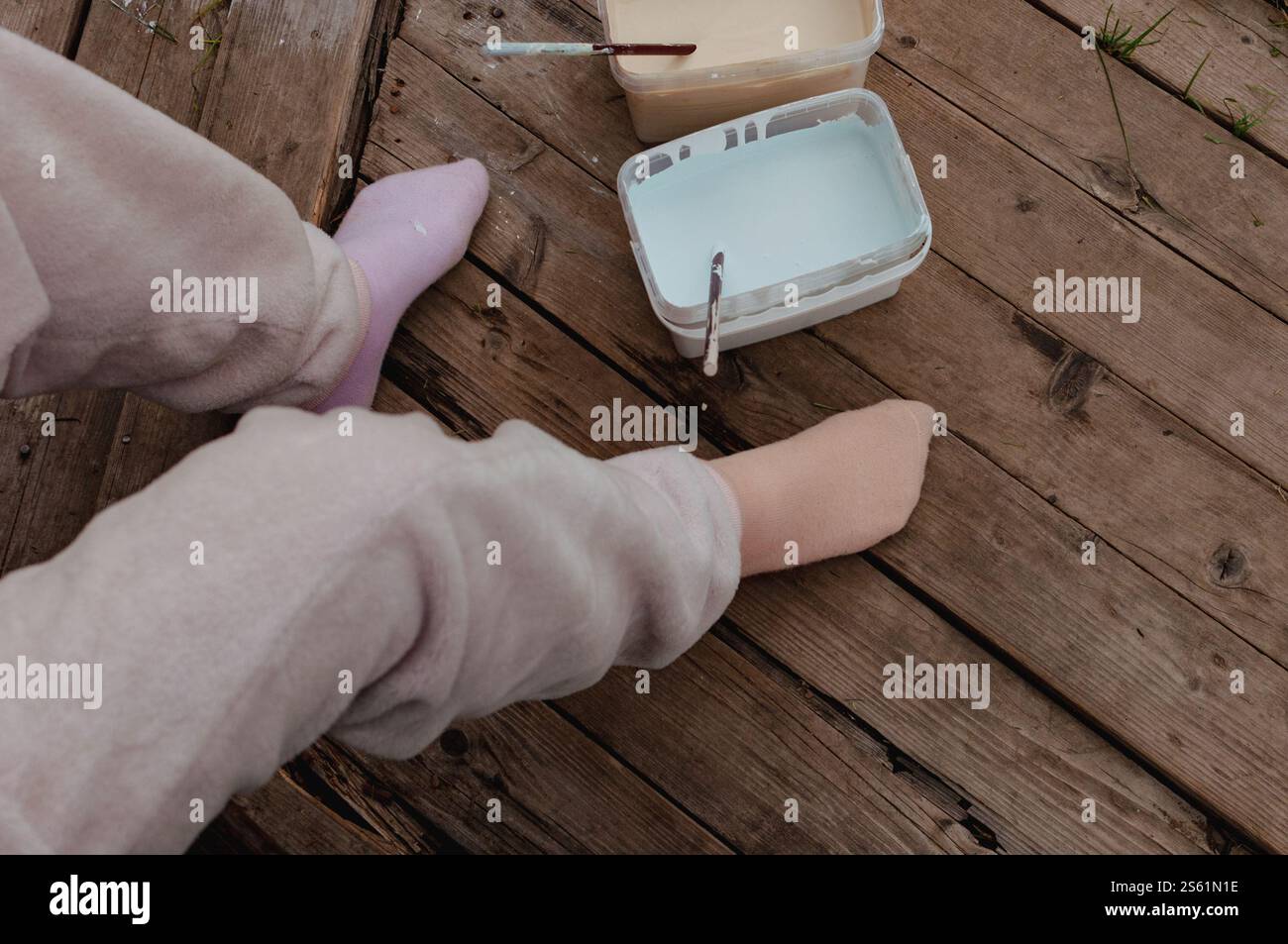 Preparing paint for renovation work, girl's legs and containers with ...