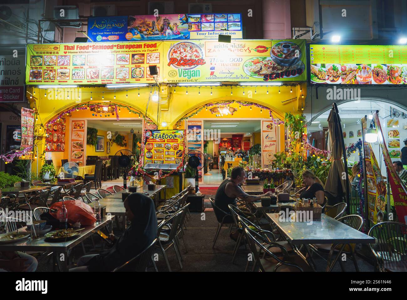 A vibrant street side restaurant in Phuket, Thailand, with a yellow ...