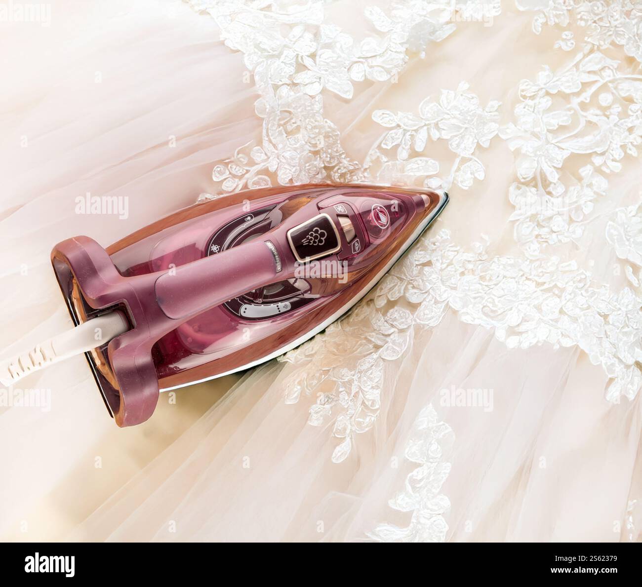 One electric iron is ironing the bride's dress, close-up, top view ...