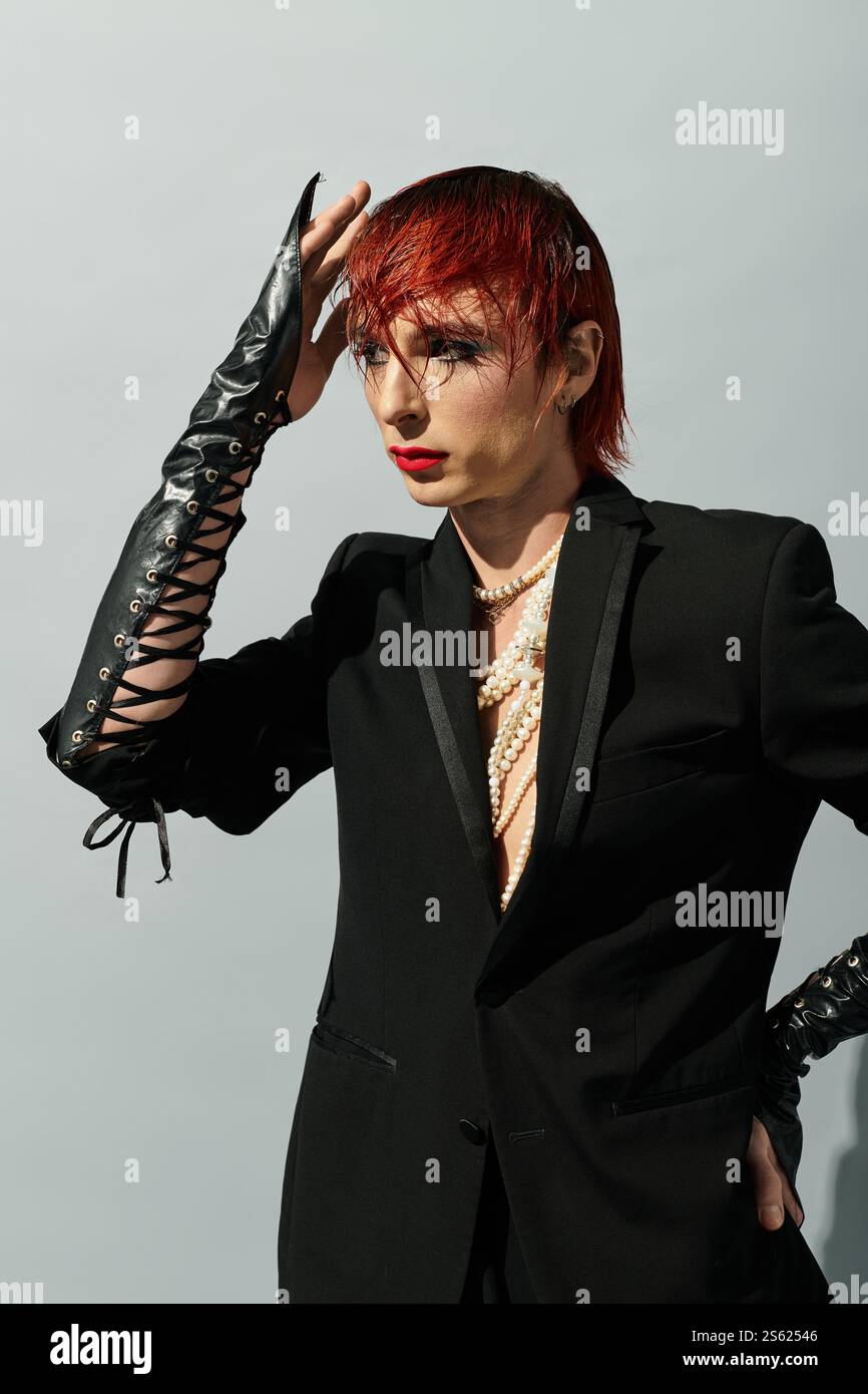 A young man styles his vibrant hair while wearing an elegant yet edgy ...